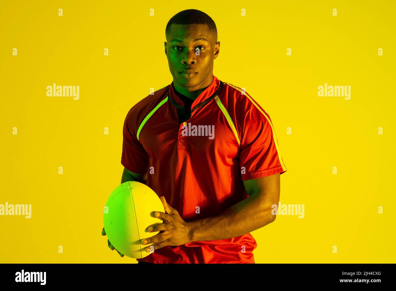 Portrait of african american male rugby player with rugby ball over ...
