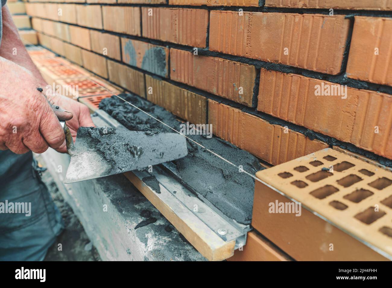 Worker or mason hands laying bricks close up. Bricklayer works at brick ...