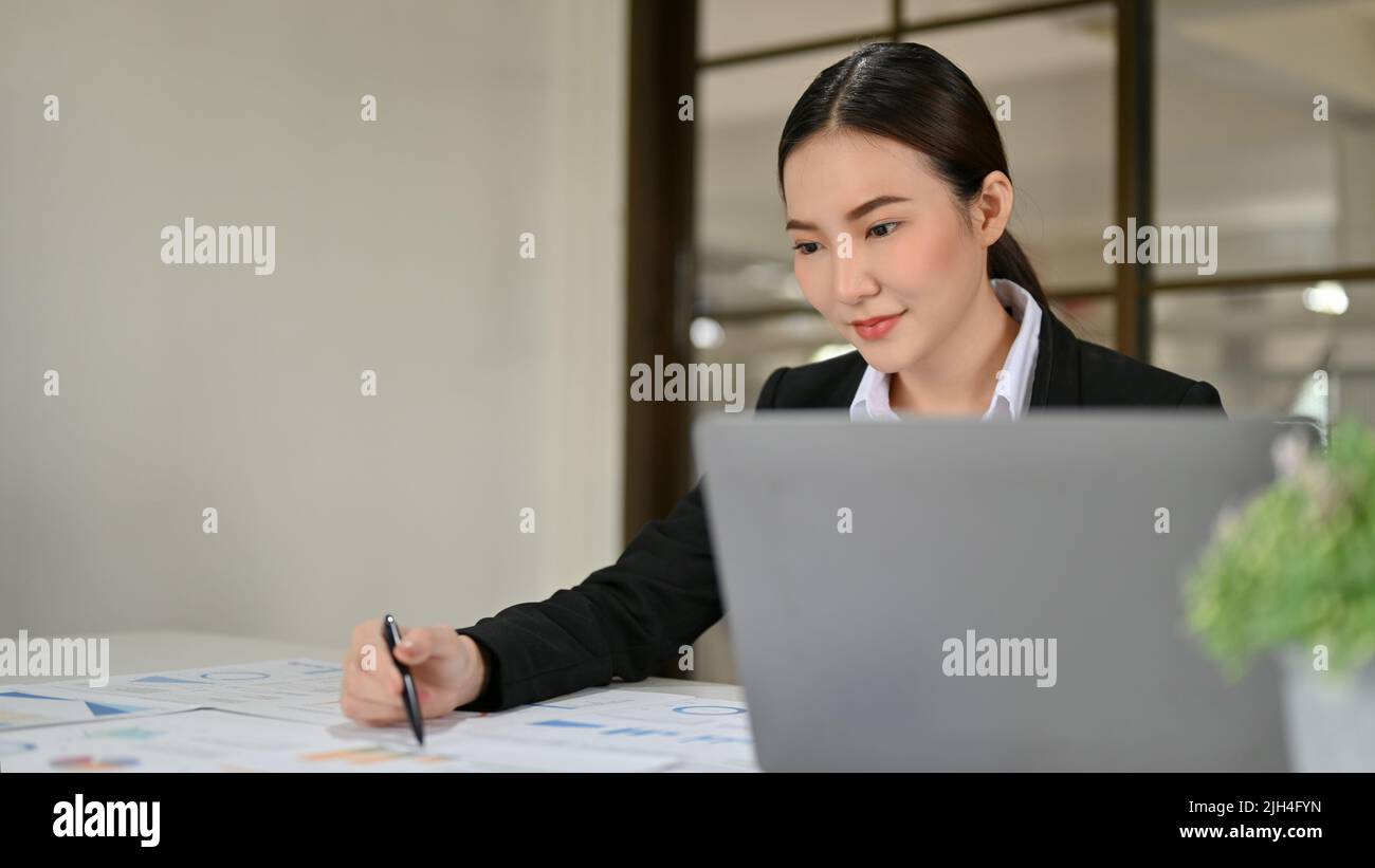 Attractive and charming young Asian businesswoman or female executive ...