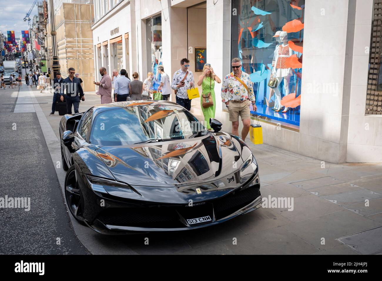 Pedestrian shoppers walk past a shiny Ferrari that has been illegally ...