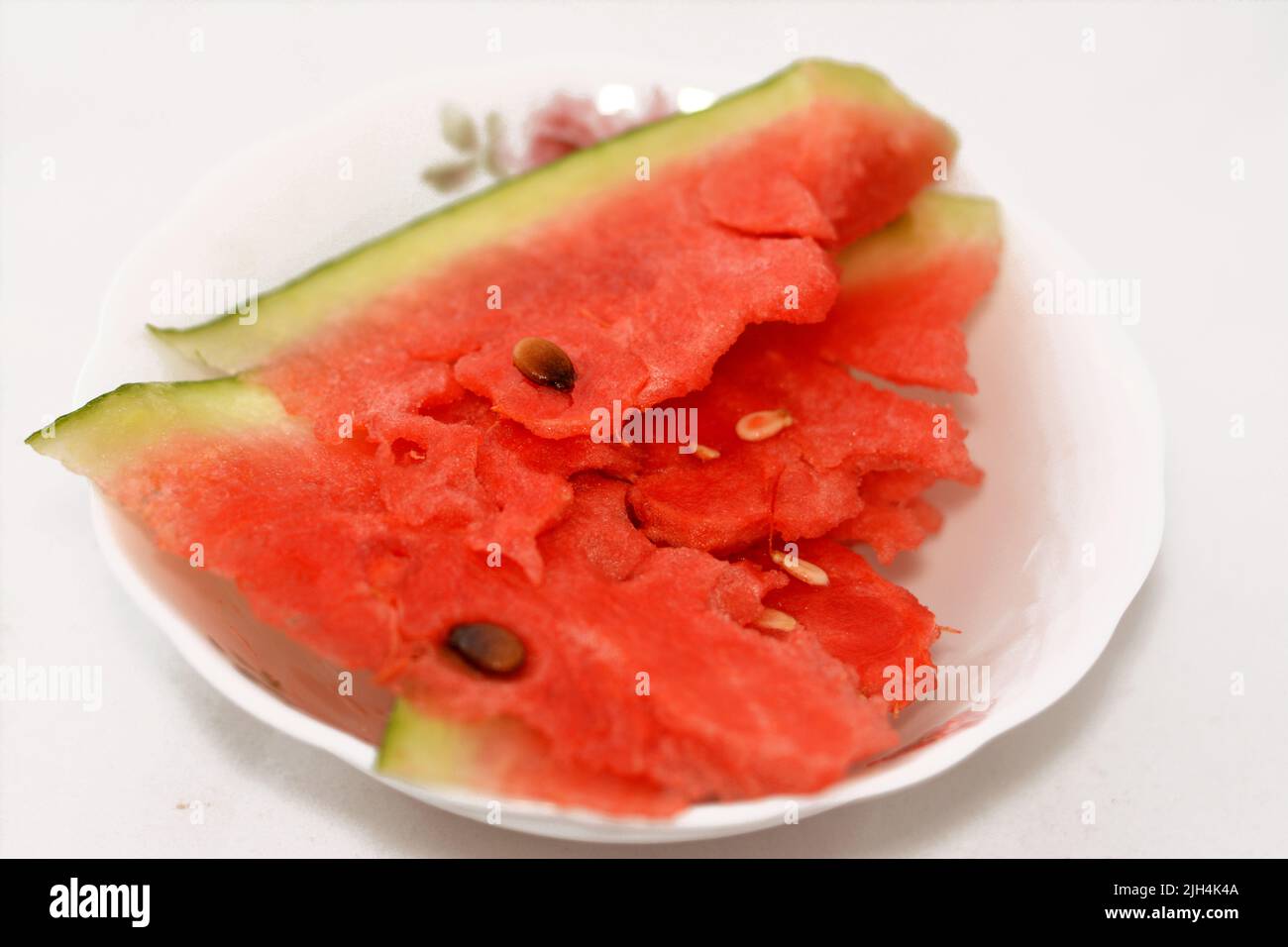 Slices of watermelon fruit cuts into pieces with seeds and its green ...