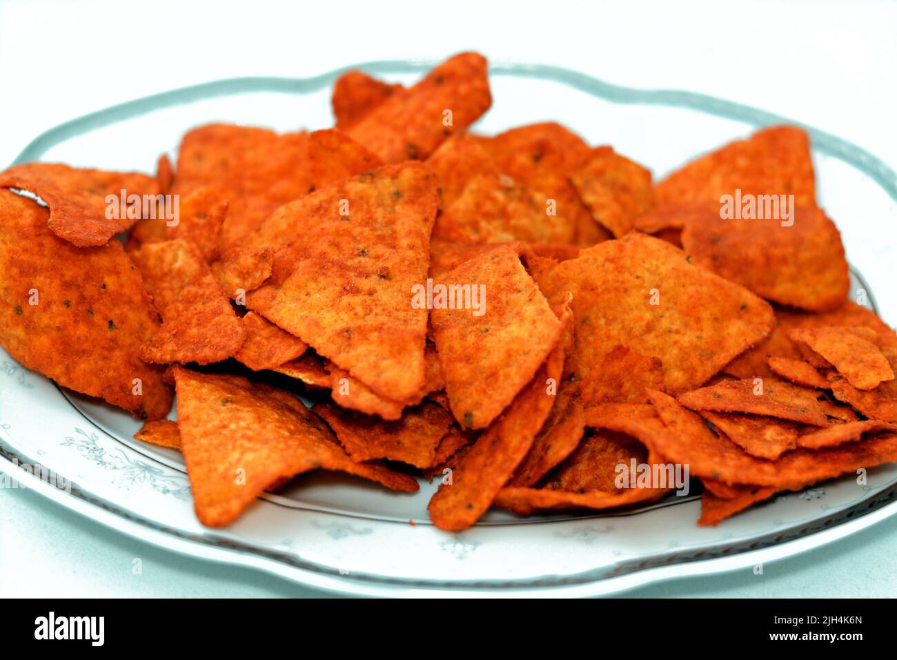 A pile of flavored tortilla chips made of corn tortillas cut into ...
