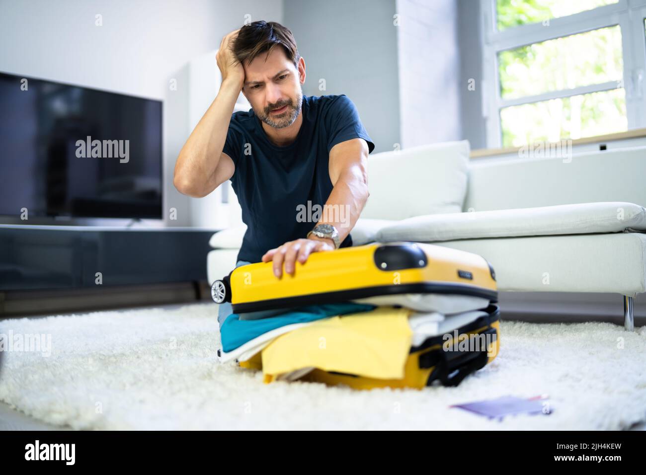 Man Packing Stuffed Suitcase Bag For Travel Stock Photo - Alamy