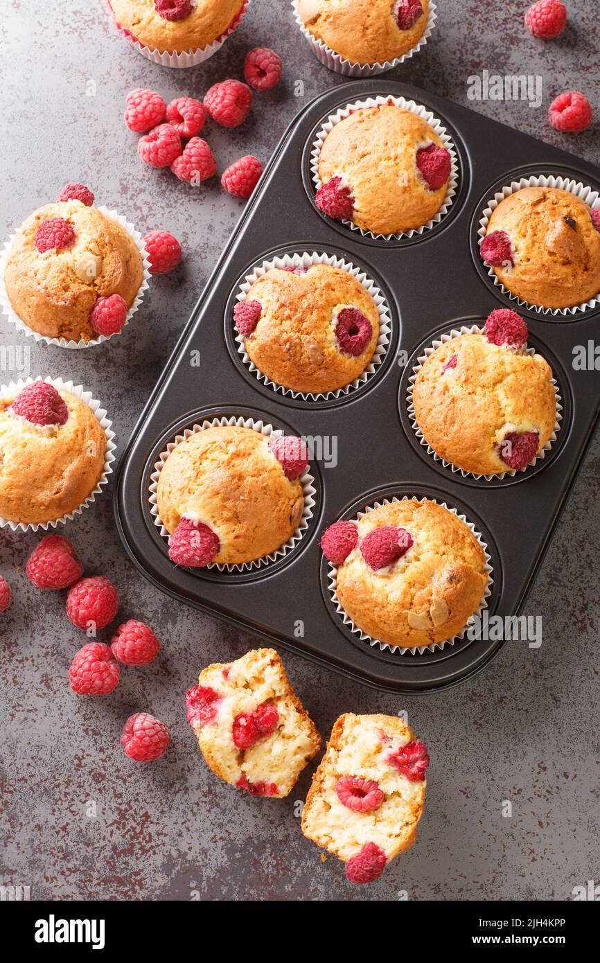 Summer raspberry muffins with white chocolate close-up in a muffin pan ...