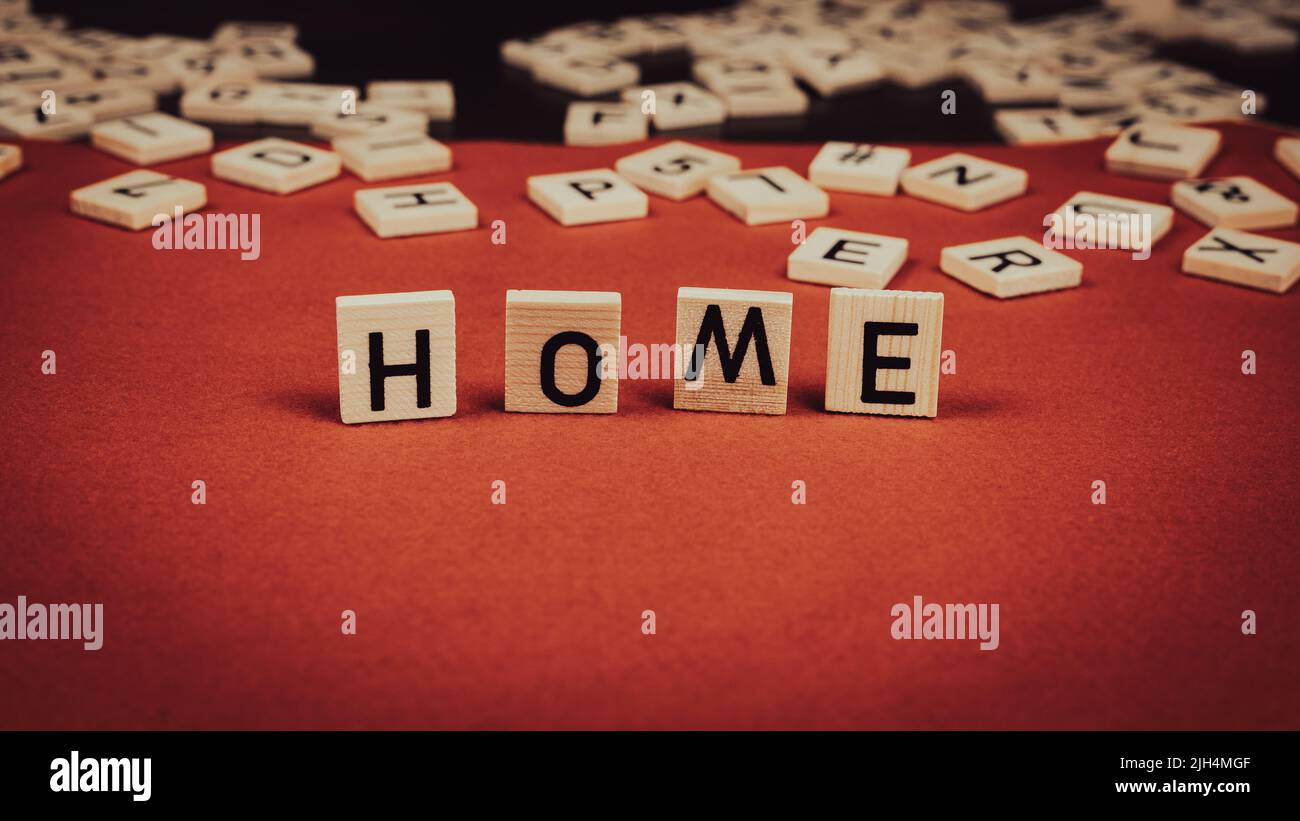 Word "Home" composed of wooden tiles with letters on a red felt ...