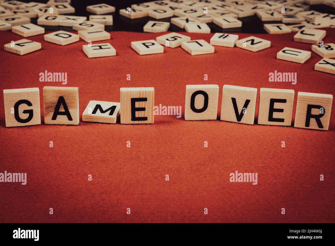 "Game over" phrase composed of wooden tiles with letters on a red felt ...