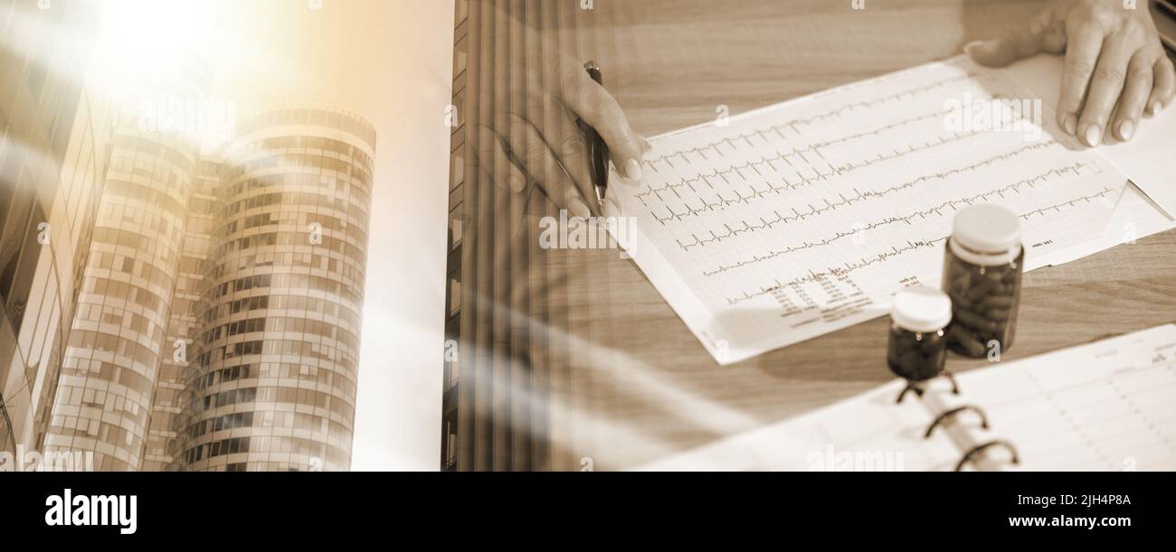 Female cardiologist examining an ecg graph in medical office; multiple ...