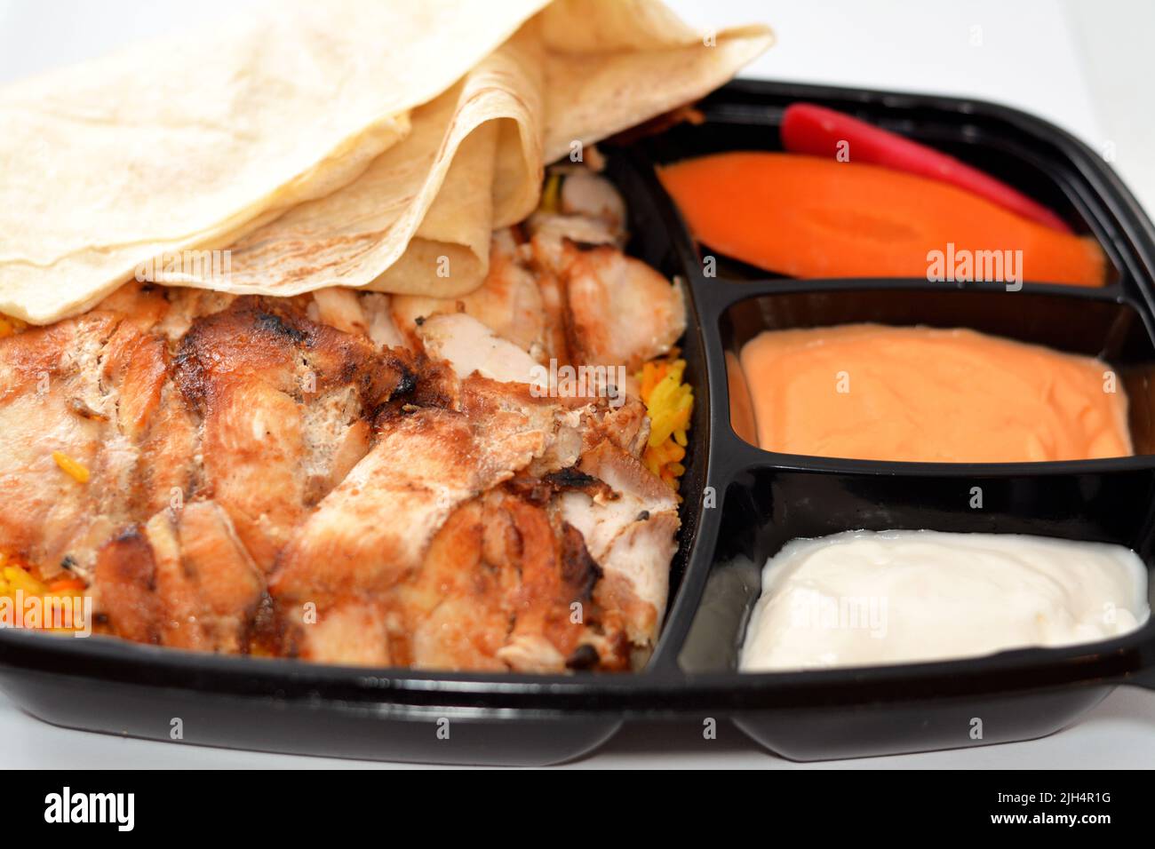 Arabic Syrian cuisine of Chicken Shawarma Fatteh colorful Basmati rice and Syrian bread served ...
