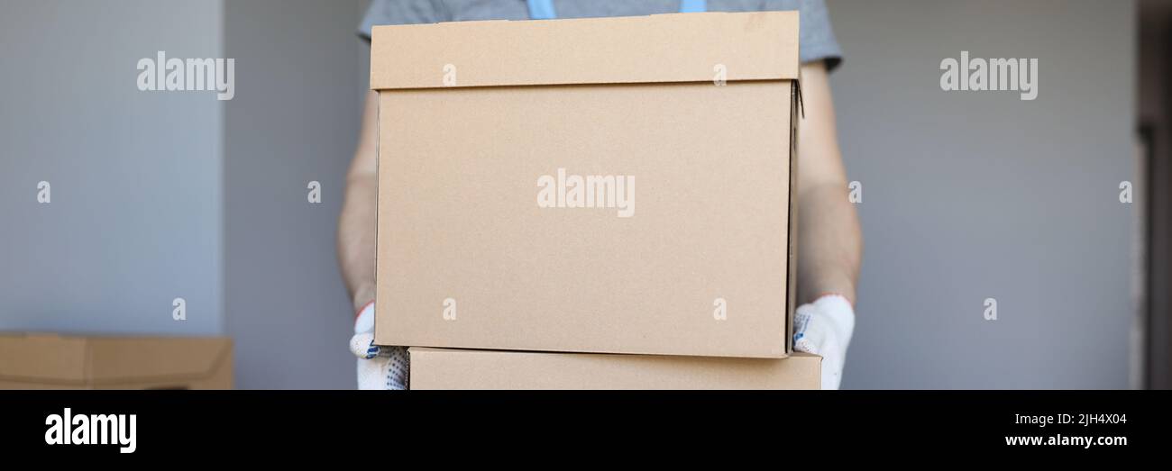 Helper carry heavy cardboard boxes with owners belongings to new house ...