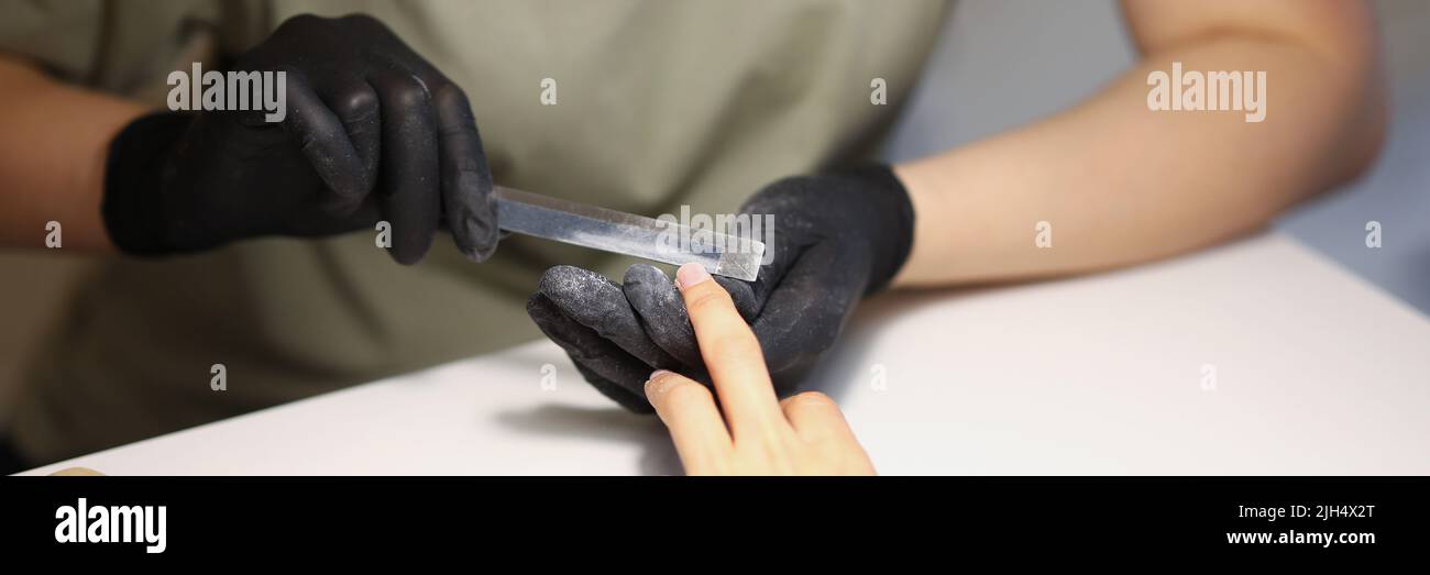 Nail master using nail file tool to create perfect shape for clients ...