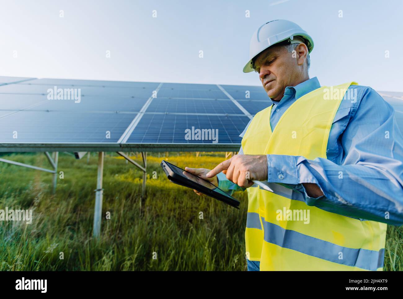 Solar engineer working with digital tablet at renewable energy farm ...