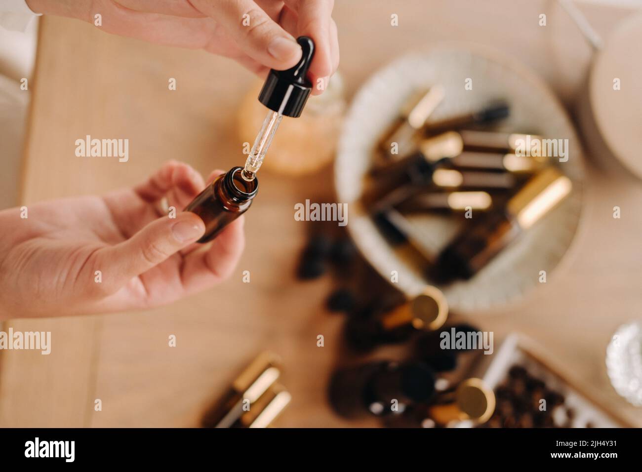Close-up of female hands holding a bottle of essential oil ...