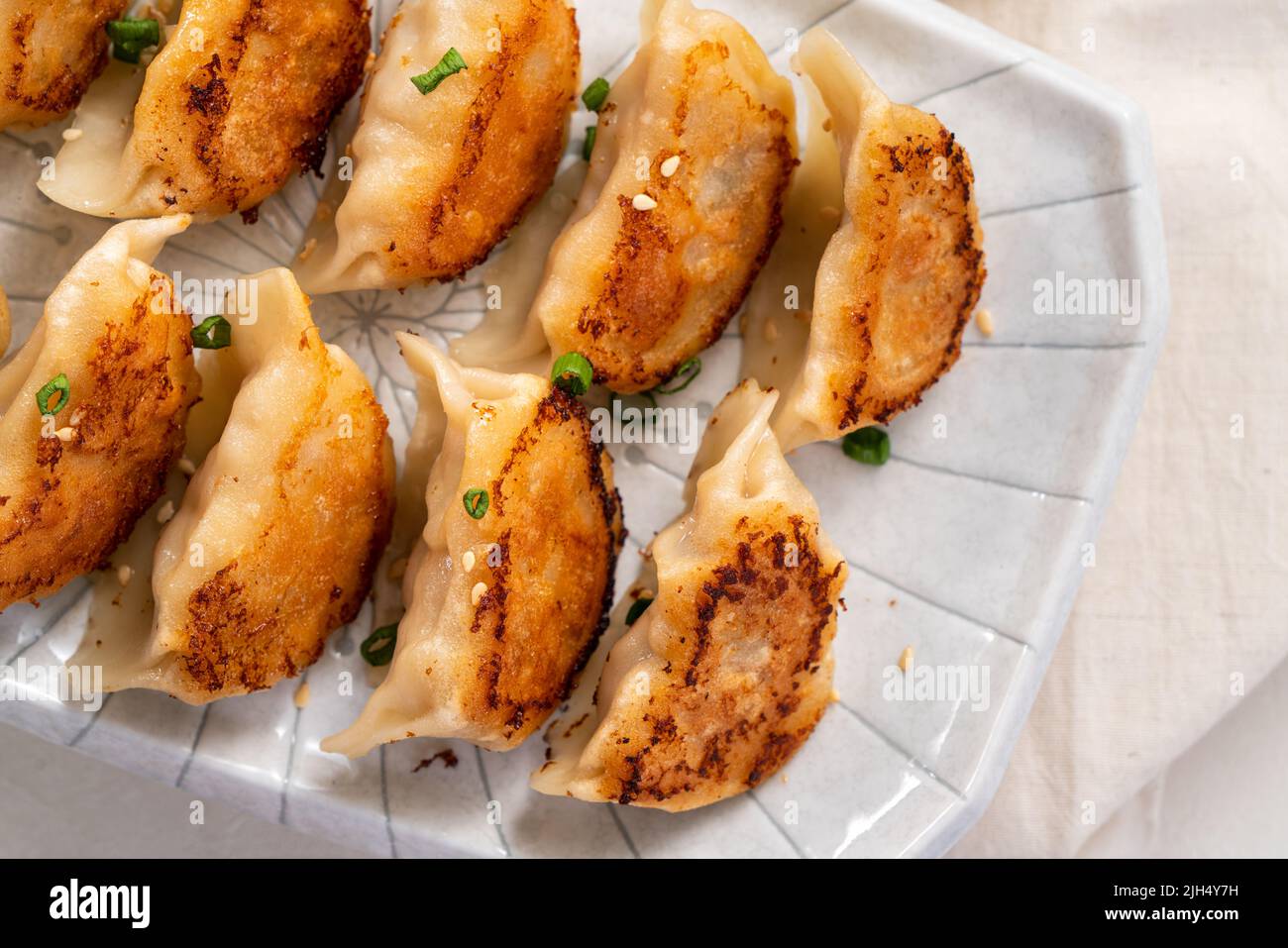Taiwanese and Japanese Pan-fried gyoza dumpling jiaozi food in a plate with soy sauce on white ...