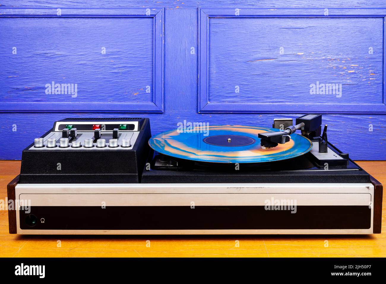 Vintage turntable vinyl record player with blue and orange vinyl on a ...