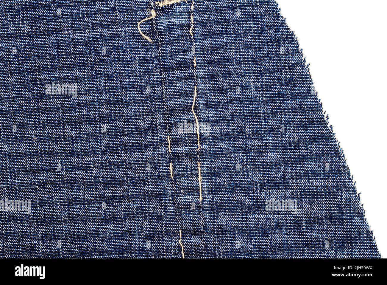 Piece of blue jeans fabric with a ripped of back pocket isolated on ...
