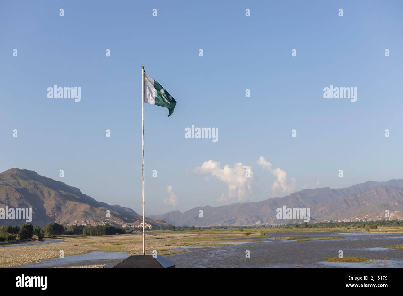Pakistan flag with a beautiful mountains and river landscape background ...