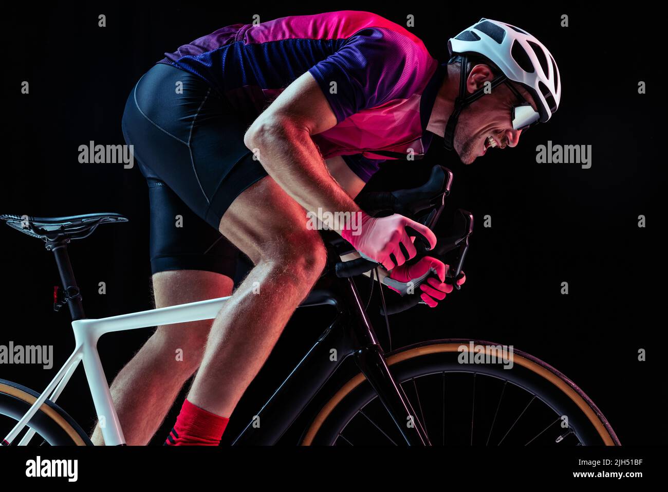 Portrait of man, professional cyclist training, riding isolated over ...