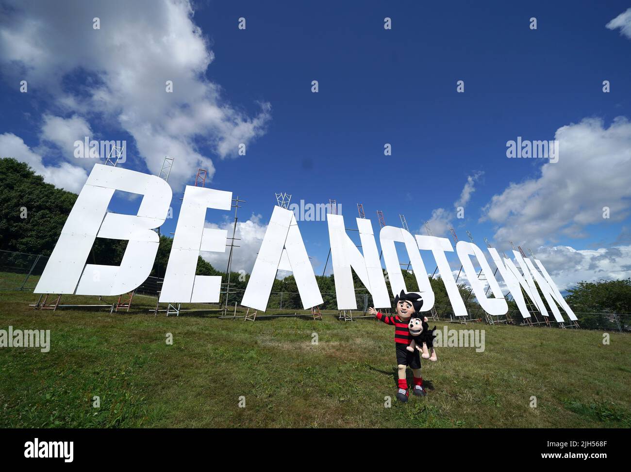 Dennis the Menace stands in front of a giant sign erected at Dundee Law ...