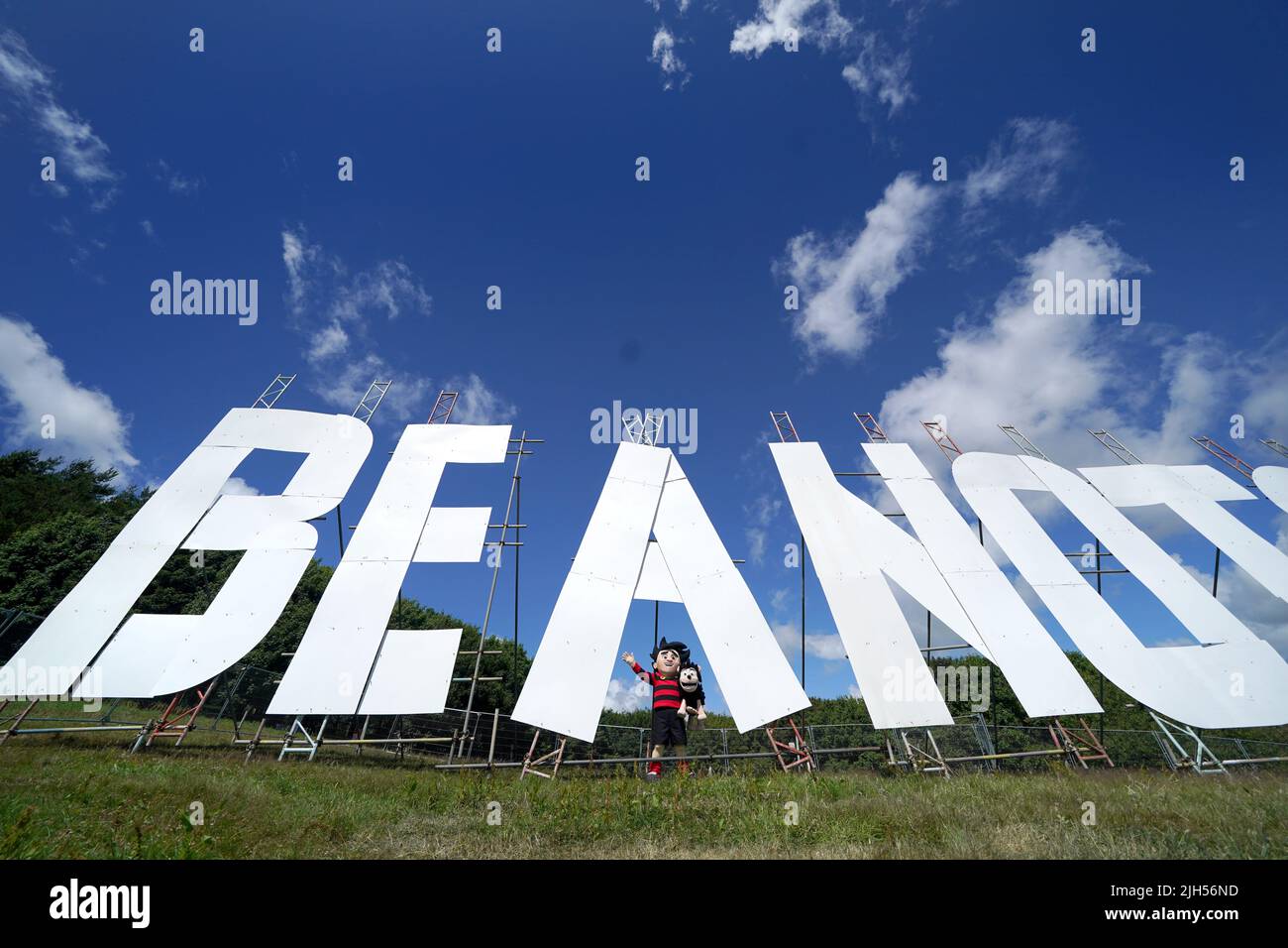 Dennis the Menace stands in front of a giant sign erected at Dundee Law ...