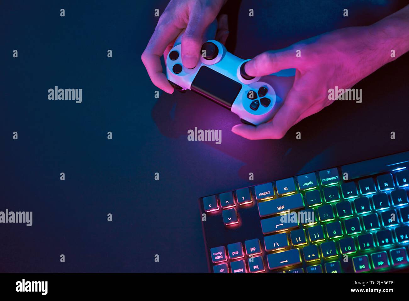 Male hands using controller for controlling computer. Rainbow colors ...