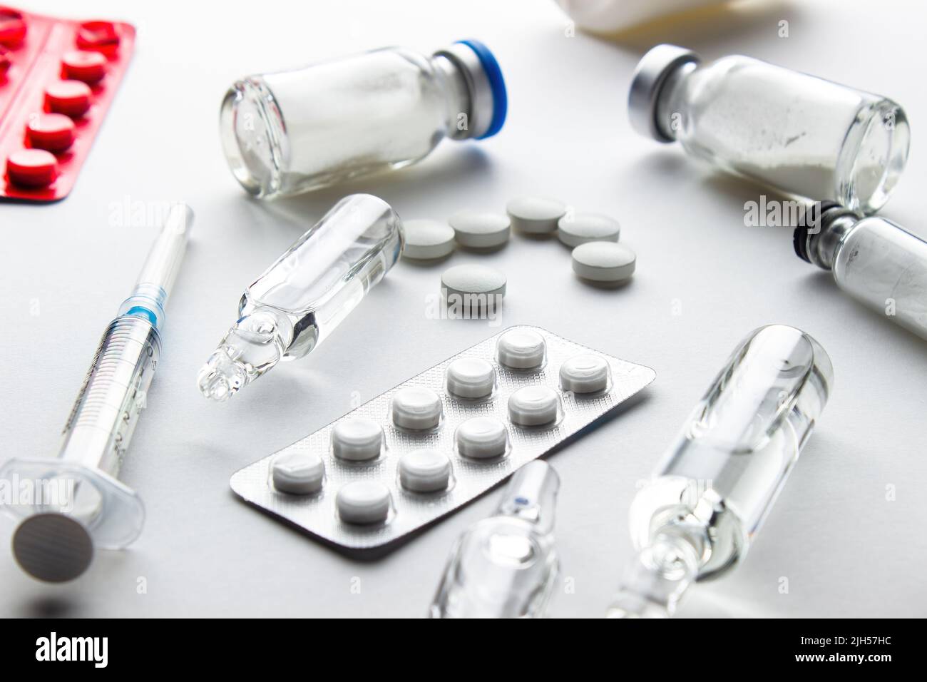 Medicines on a white background: tablets in blister and loose, ampoules ...