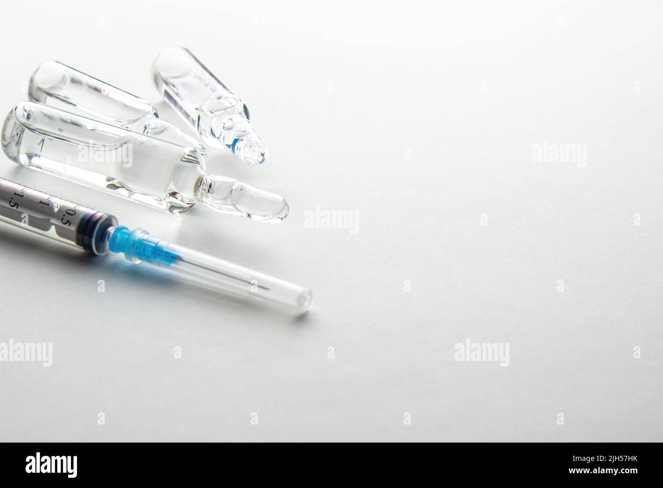 Vials and syringe on light table. Vaccination and immunization Stock ...