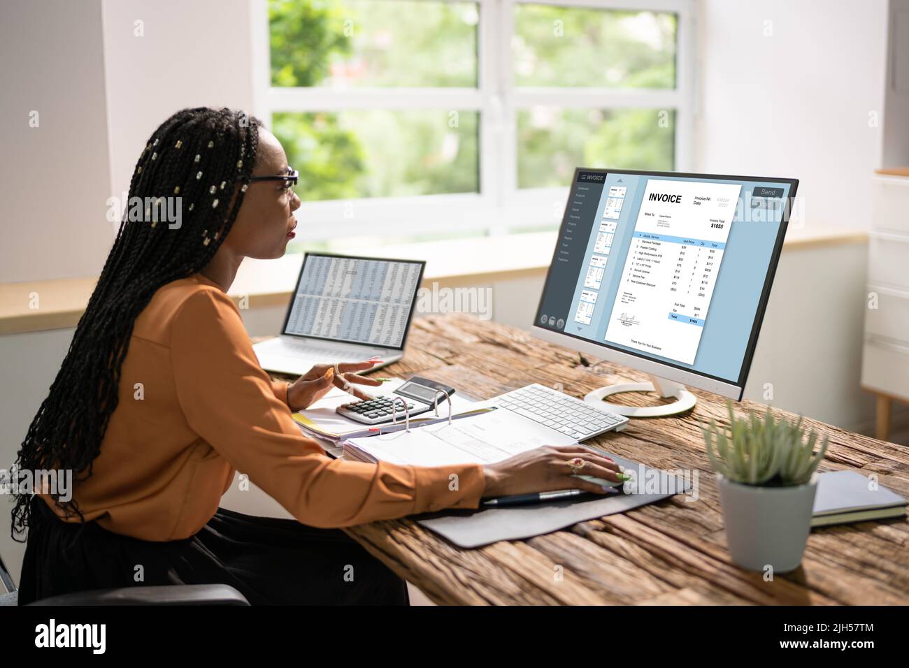 Female Accountant Calculating Tax In Front Of Computer At Desk Stock ...