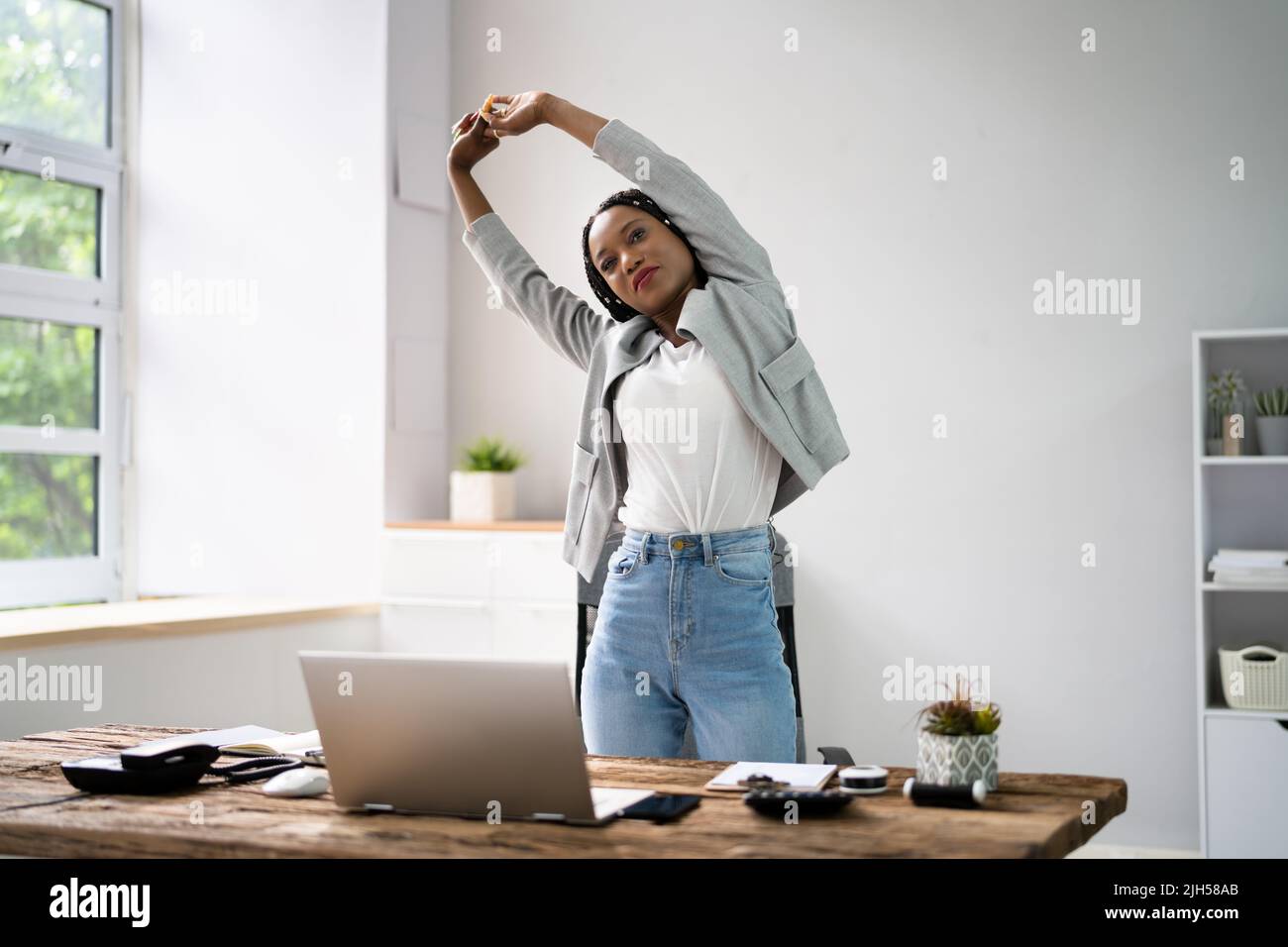 African Woman Doing Stretching Exercise At Office Desk Stock Photo - Alamy