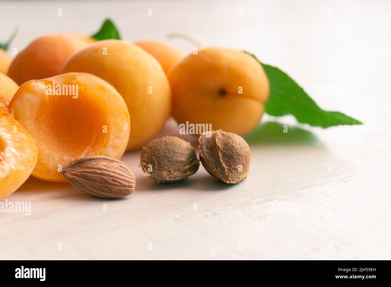 Apricots and kernel on a white wooden background. Apricot seeds Stock ...