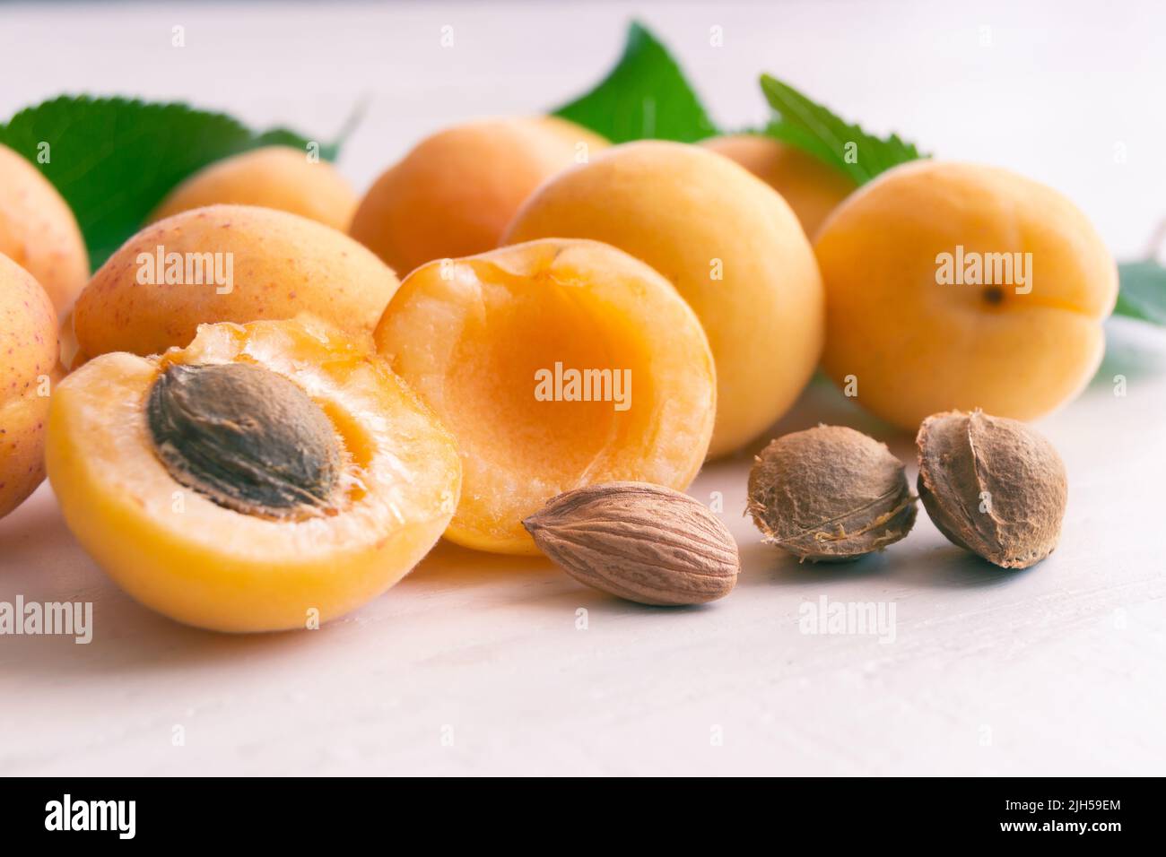 Apricots and kernel on a white wooden background. Apricot seeds Stock ...