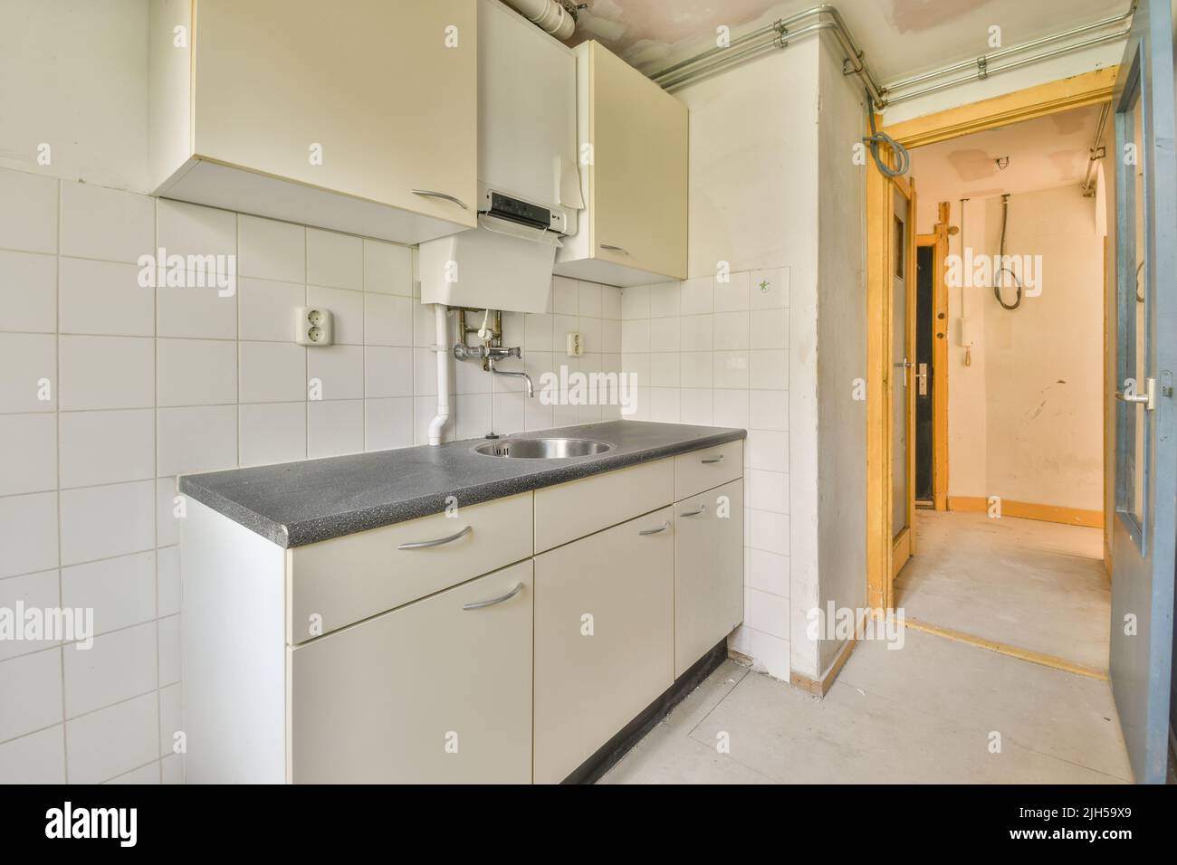 Interior of empty white kitchen with corridor and wooden parquet floor ...