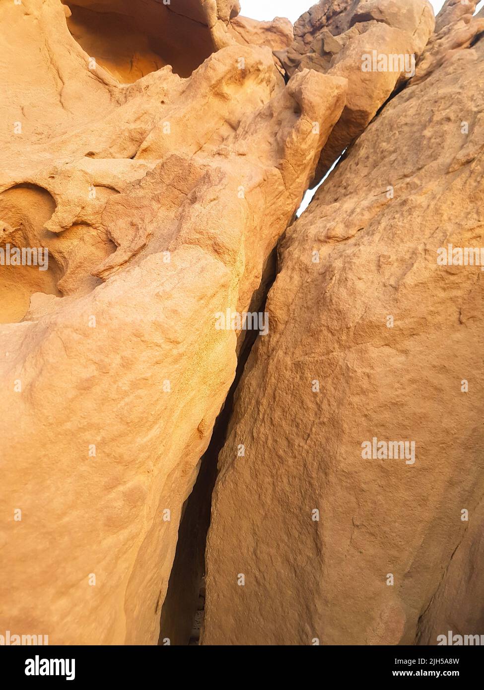 Huge sandstone rock with a crack in the middle of it. Yellow limestone ...