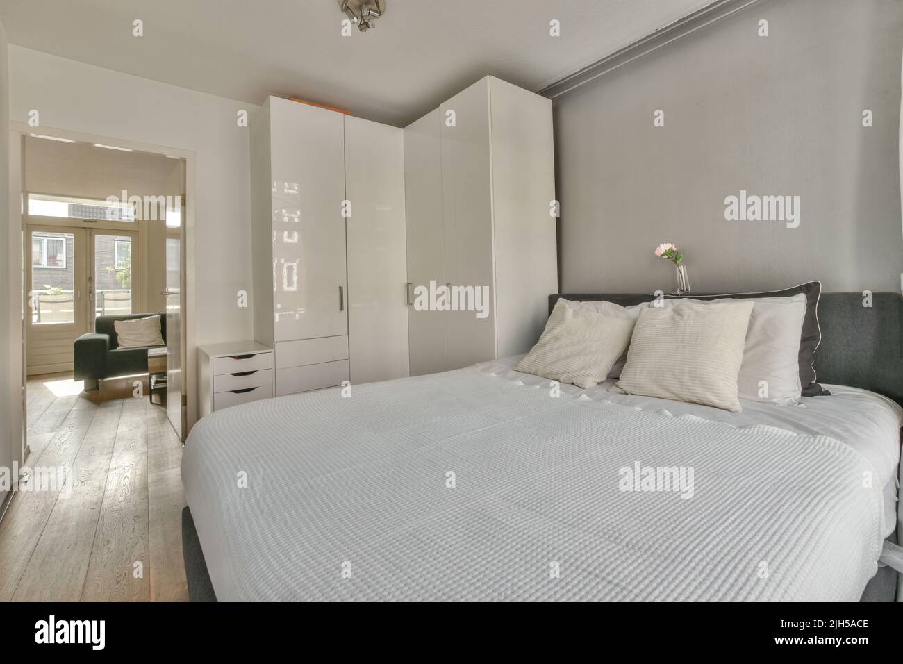 Home interior design of bedroom with bed and wooden wardrobe placed in ...