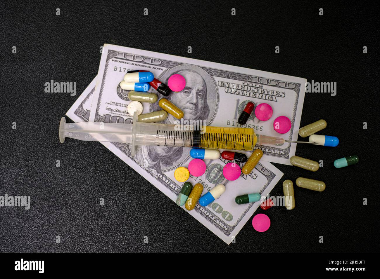 Drug medicine syringe and money banknote on the black background ...
