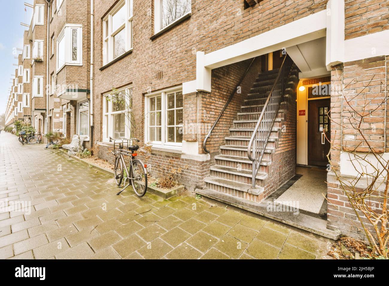 The front view of a brick building with signs, pavement and wooden ...