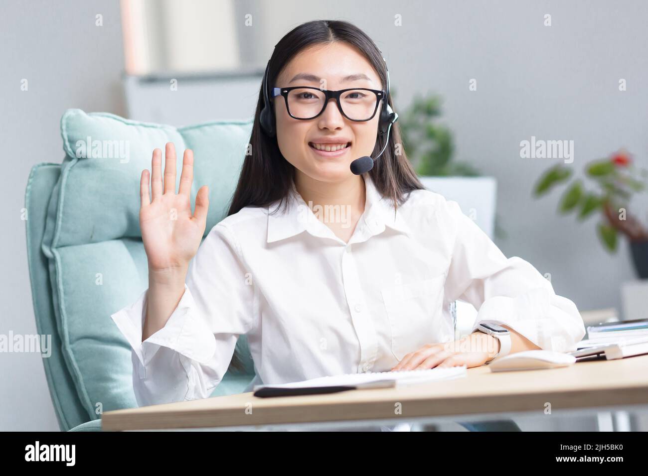 Woman smiles waves hand in hi-res stock photography and images - Alamy