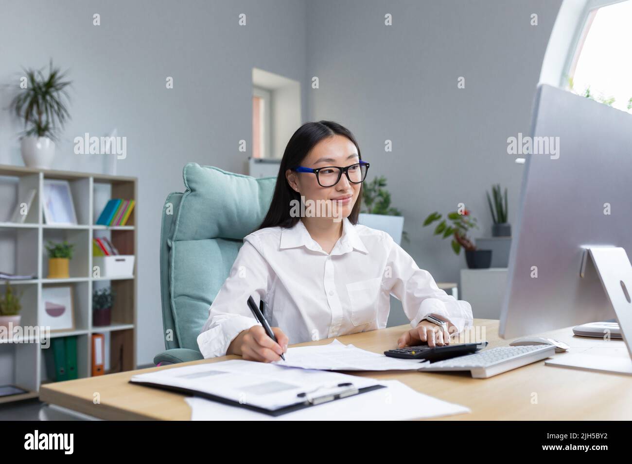 Work with documents. Portrait of a young beautiful business woman Asian ...