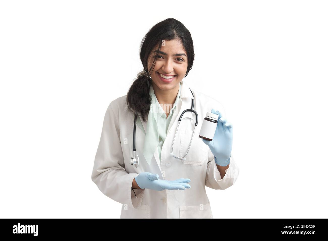 Young Venezuelan female doctor smiling and pointing at a pill bottle ...