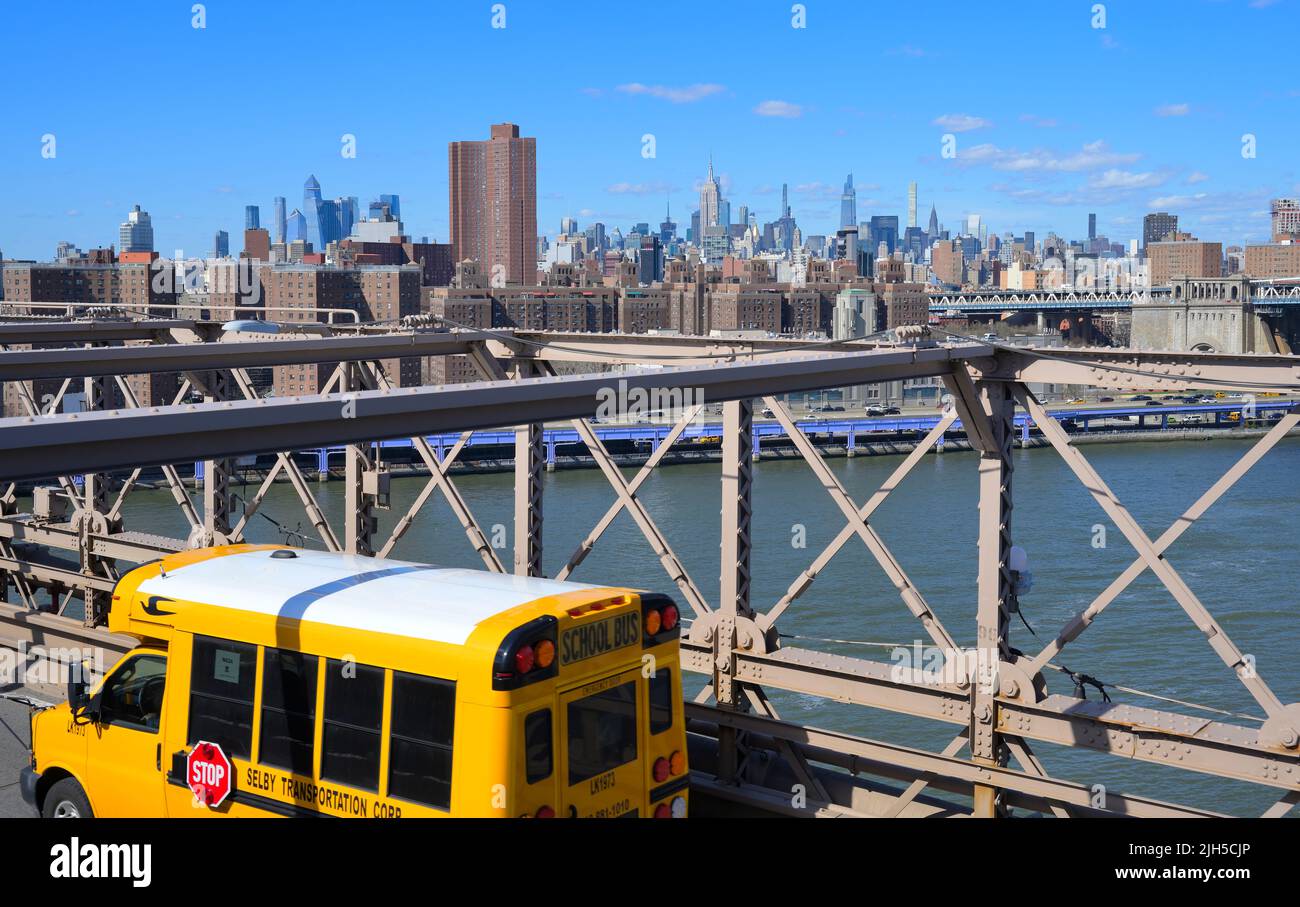 A yellow school bus crossing the iconic Brooklyn bridge on a crisp ...
