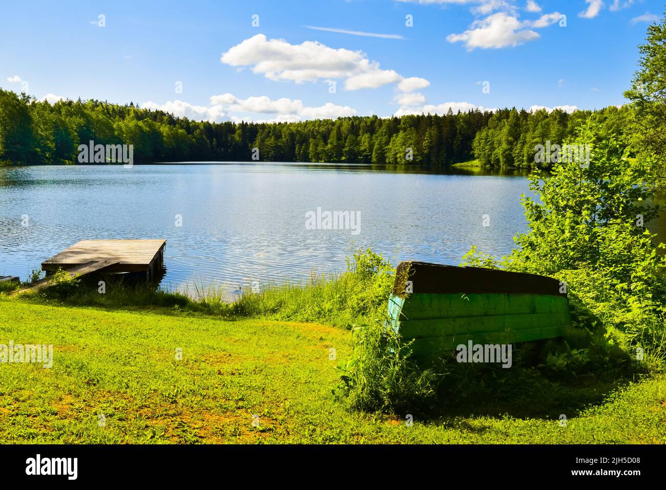 Boats upside down by calm blue lake shore in countryside of Lithuania ...
