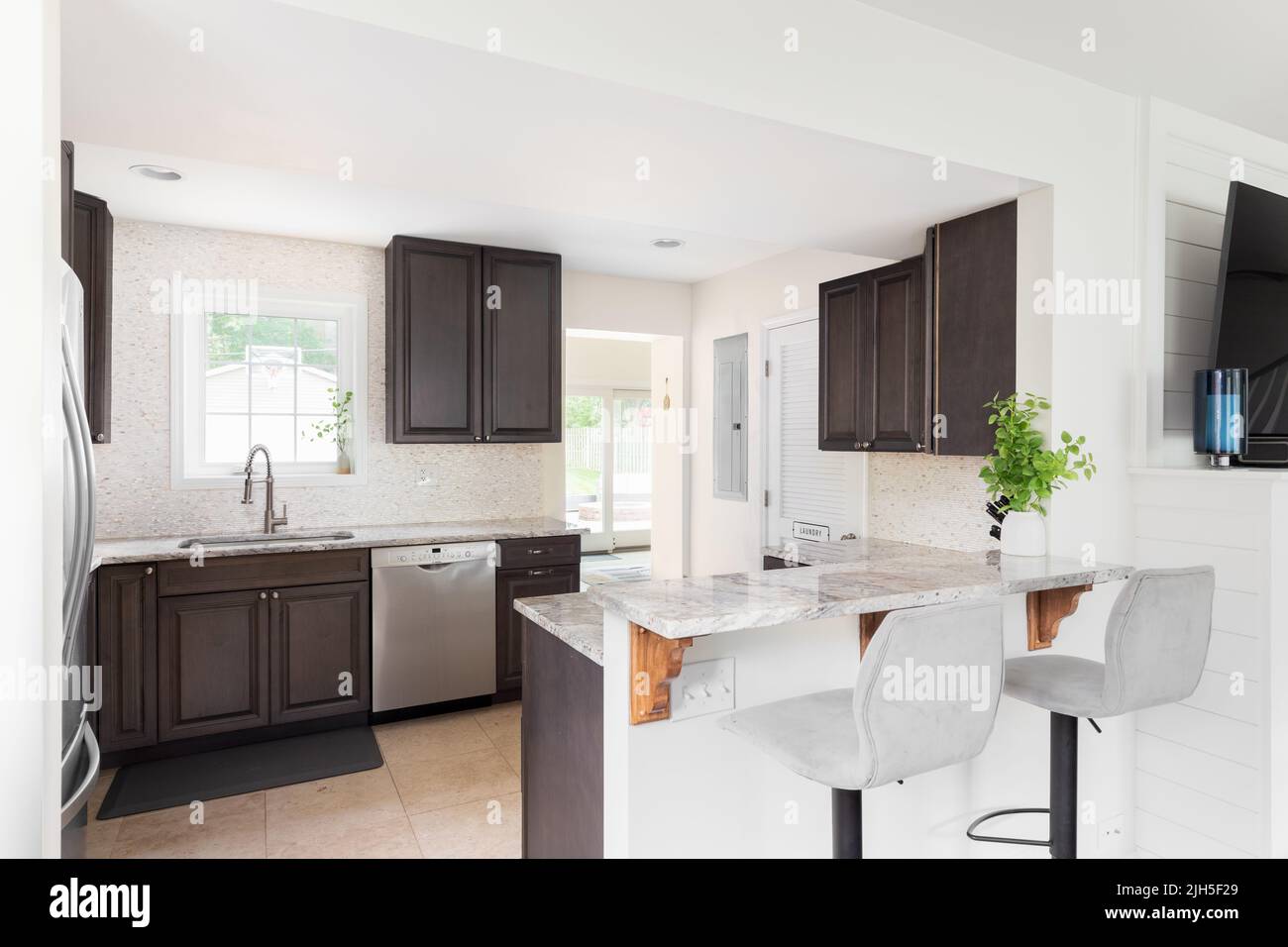 A small farmhouse kitchen with wood cabinets, granite countertops, and ...