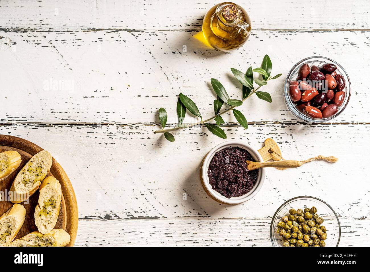 Olive pate with ingredients - olive oil, olives, capers on white wooden ...