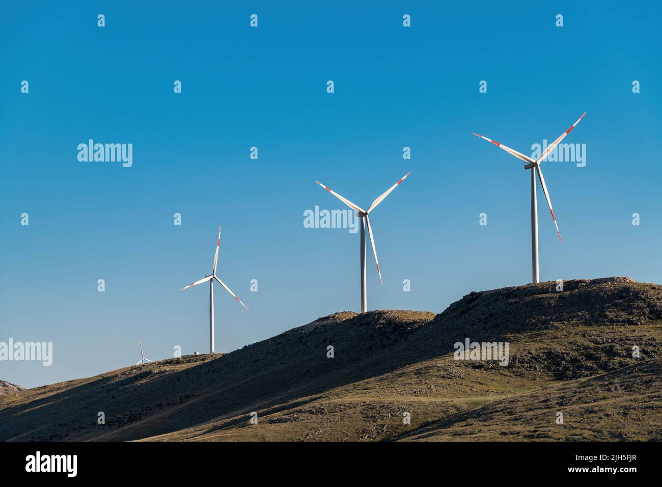 clean electricity producing wind turbine or windmill built on a windy ...
