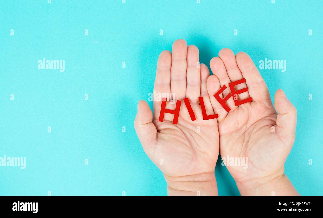 Holding the word help in the hands, german language, giving support and ...