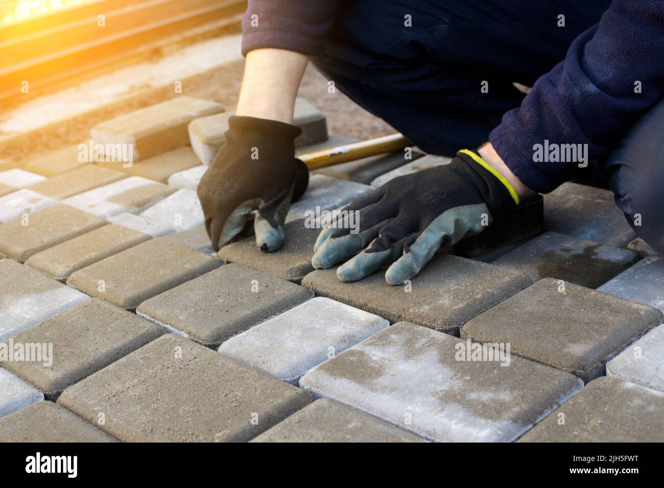 Defocus paver master. Man lays paving stones in layers. Garden brick ...