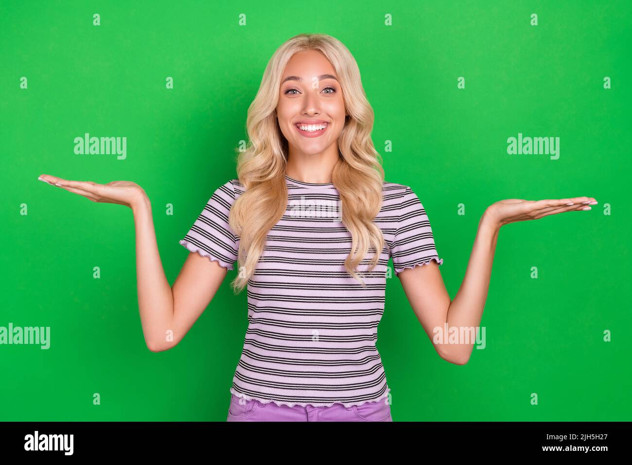 Portrait of cheerful pretty lady arms palms demonstrate empty space ...