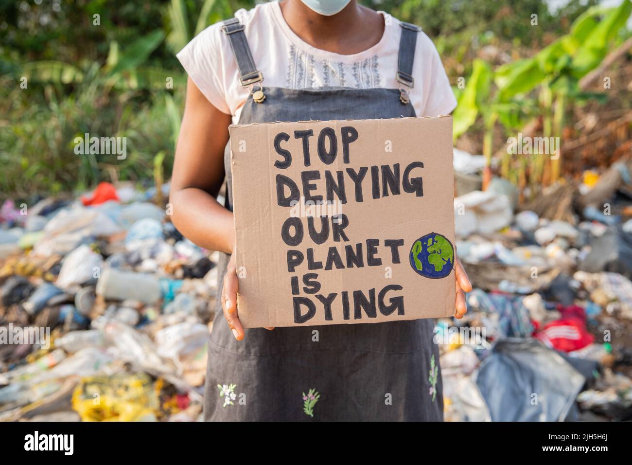 Close-up of a sign with written: "Stop denying our planet is dying ...