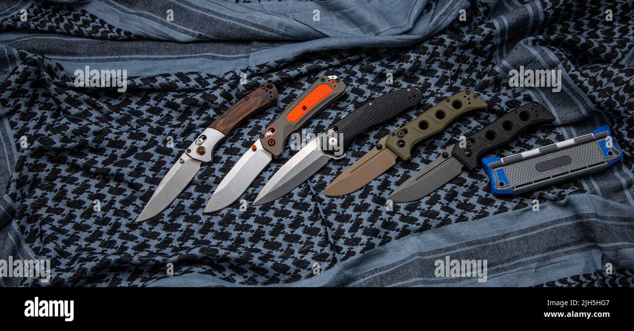 Various pocket knives with retractable blades. Light fabric background ...
