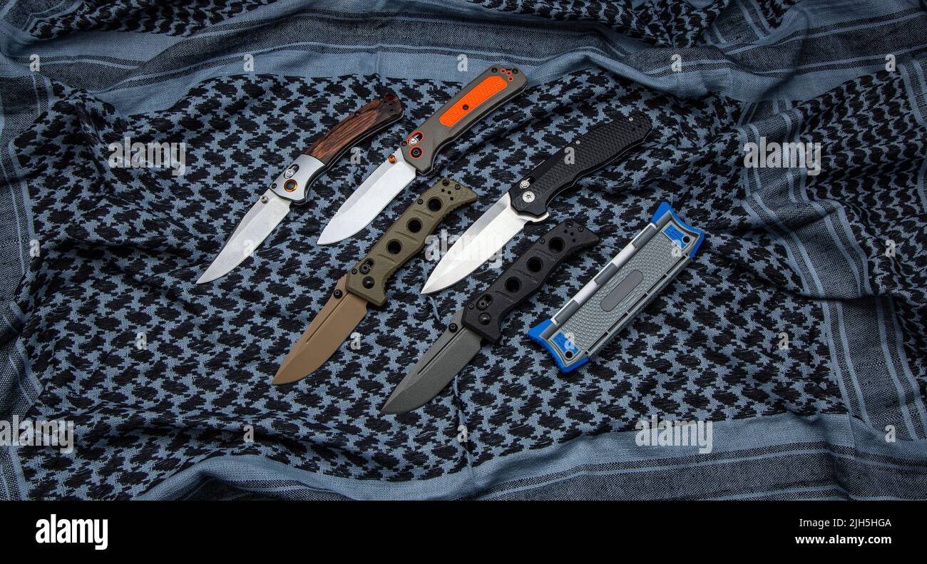 Various pocket knives with retractable blades. Light fabric background ...
