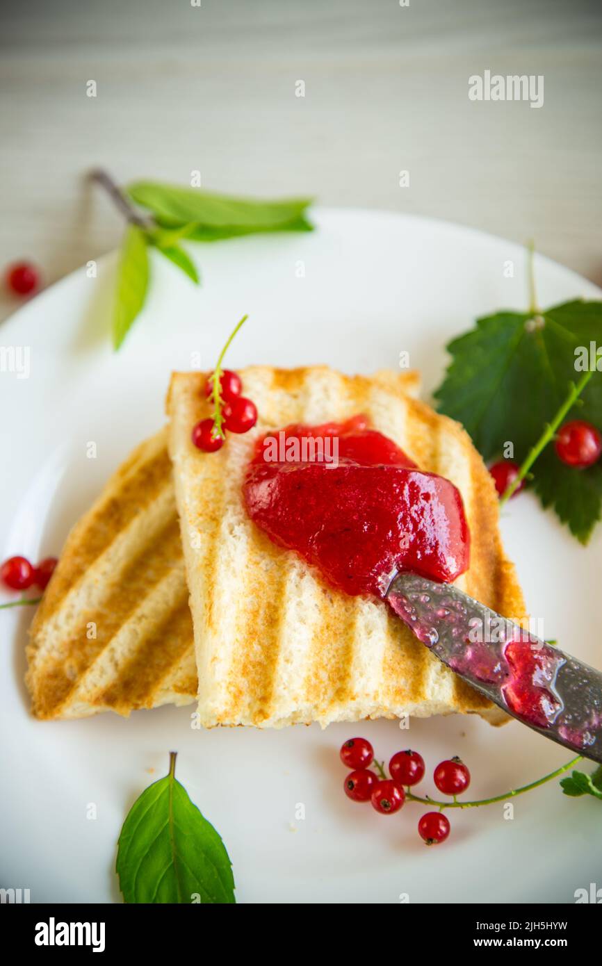 fried bread croutons for breakfast with redcurrant jam in a plate with ...